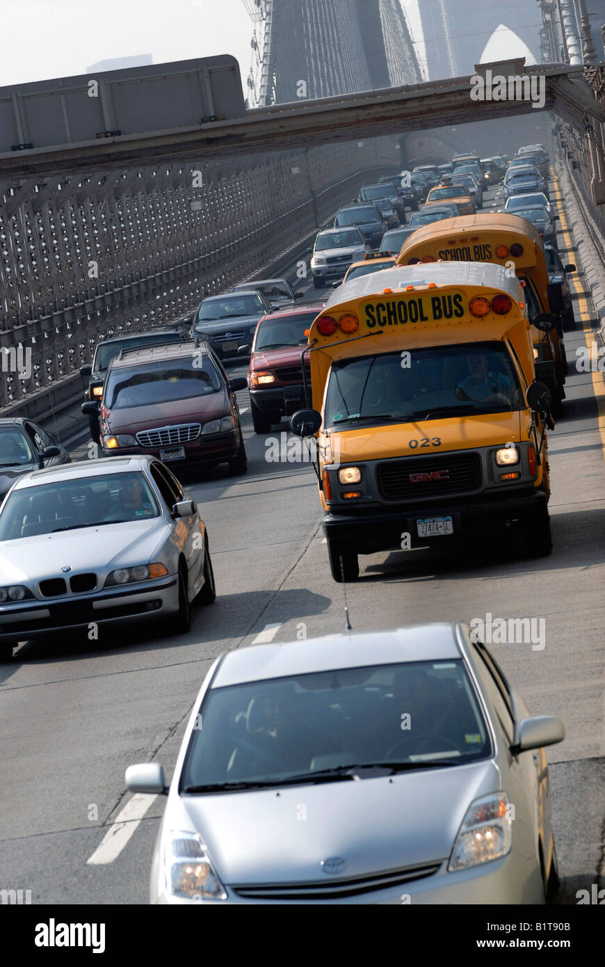 Commuters in their cars and school bus in rush hour traffic jam on the ...
