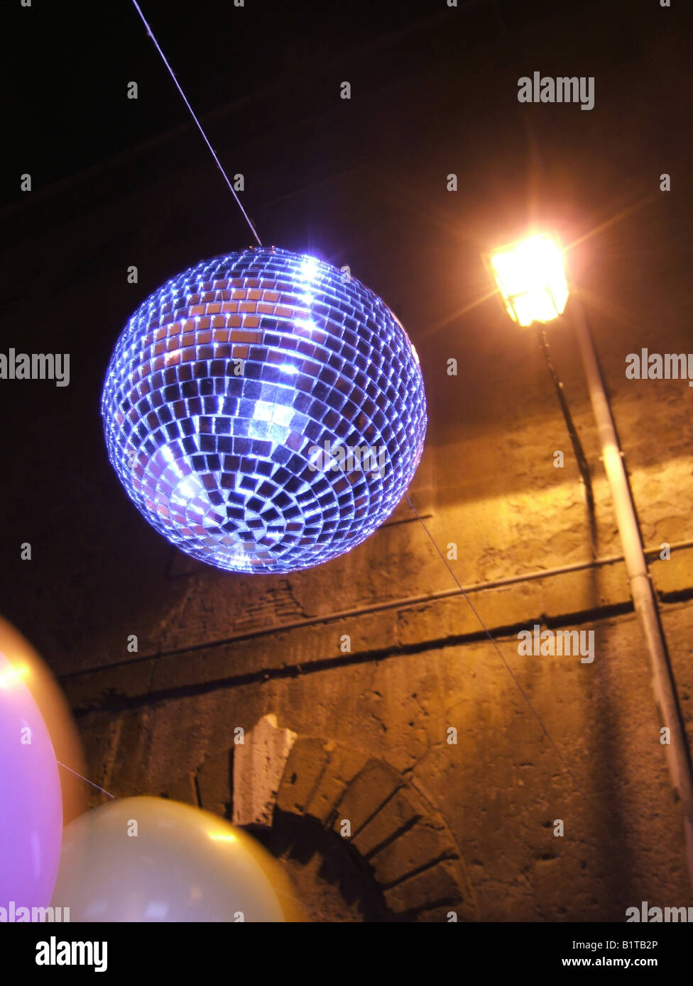 one illuminated glitter ball street party at night Stock Photo - Alamy