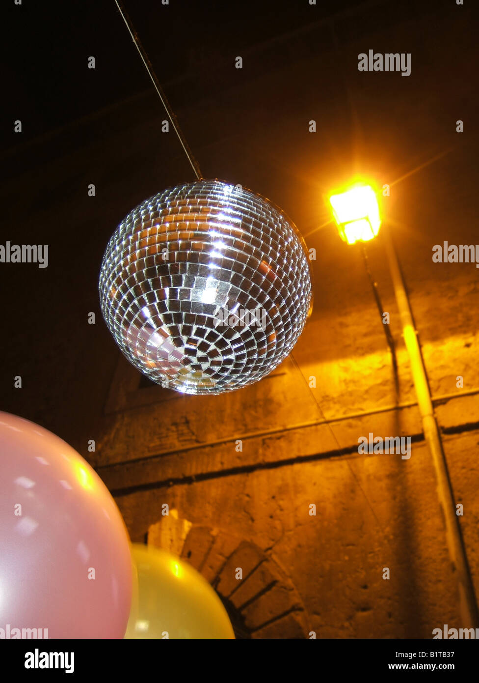 one illuminated glitter ball street party at night Stock Photo - Alamy