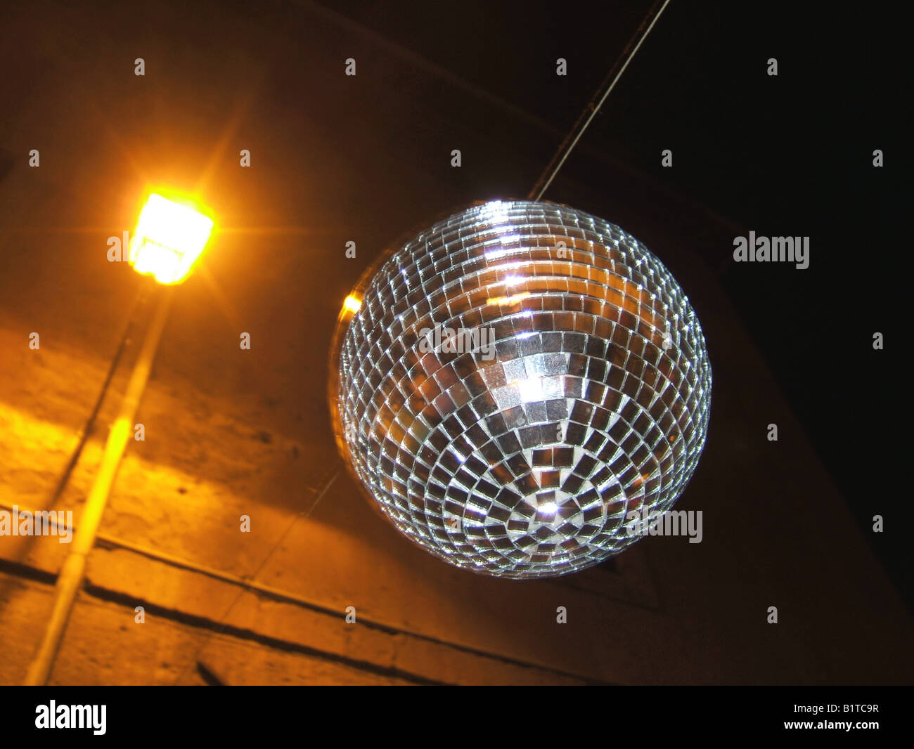 one illuminated glitter ball street party at night Stock Photo - Alamy