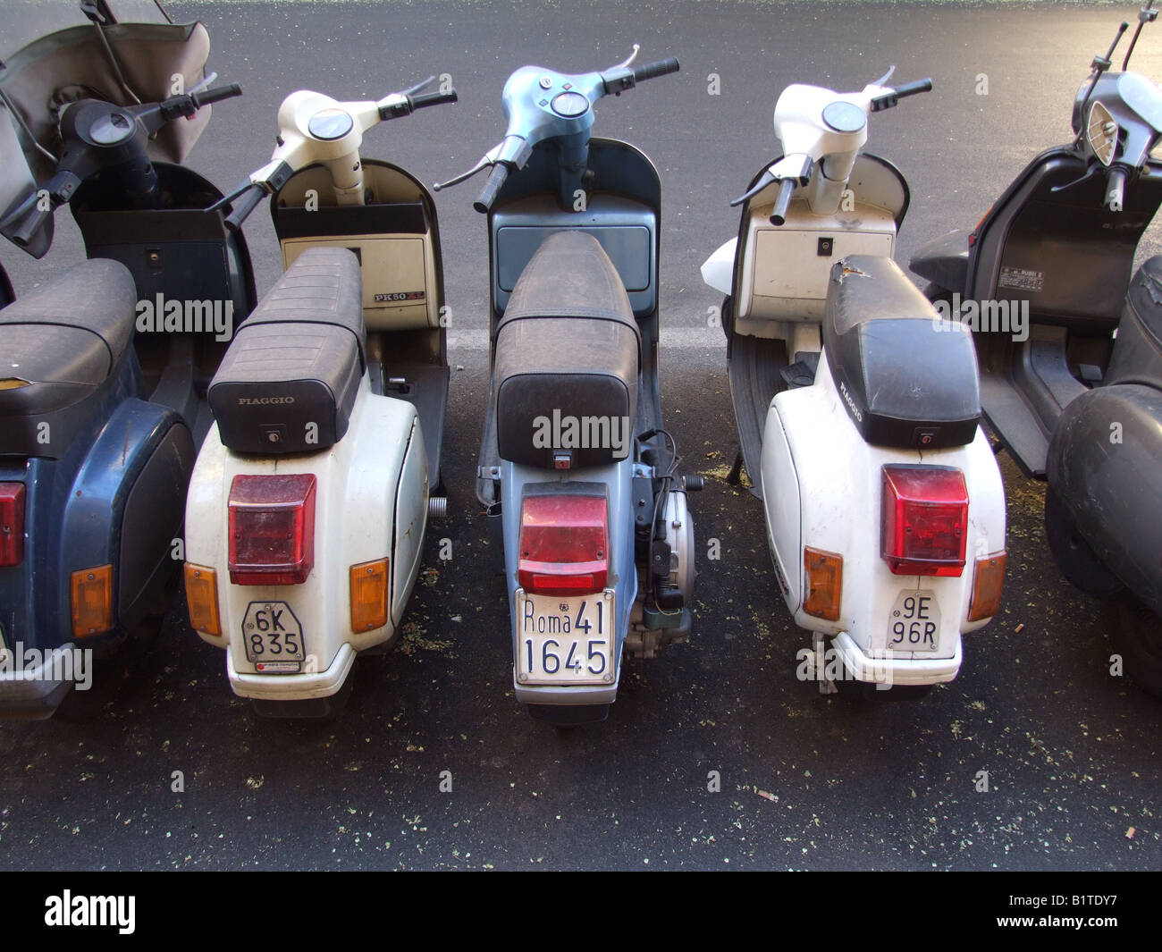 row of vespa scooters parked in street rome italy Stock Photo - Alamy