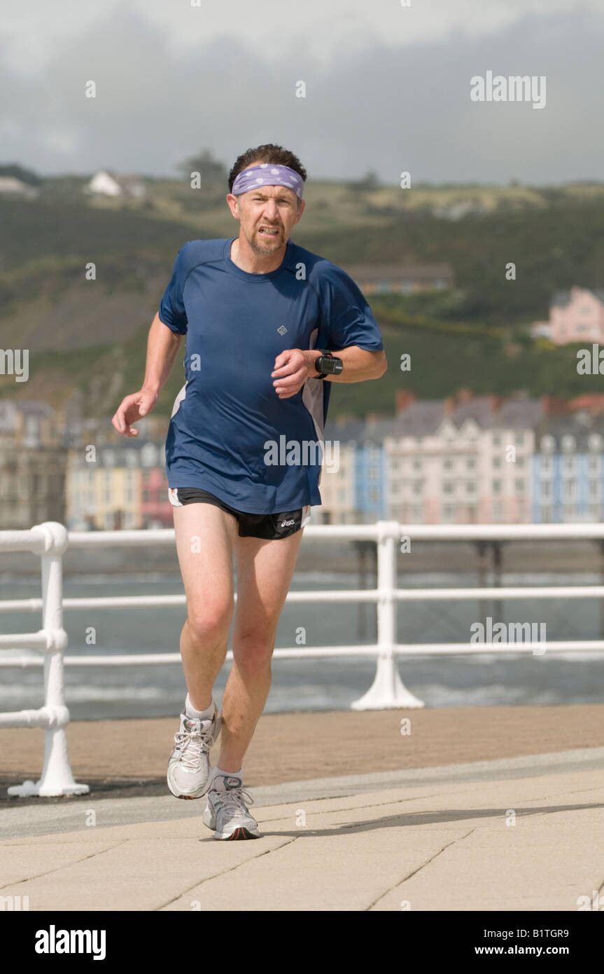 one man running alone on Aberystwyth promenade Wales UK Stock Photo - Alamy
