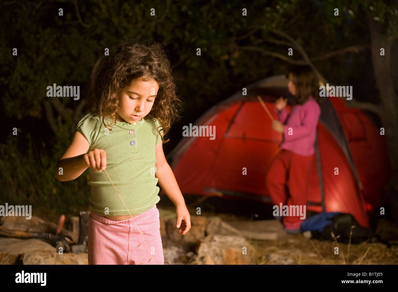 two girls in a camp site by night Stock Photo - Alamy