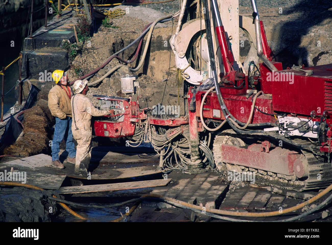 Two men work a drilling machine Stock Photo - Alamy