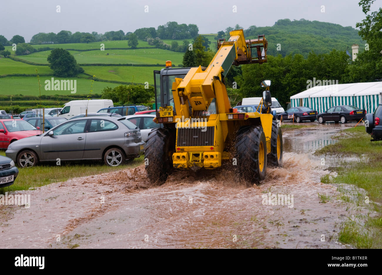 Tractor driving thru flooded car park at The Guardian Hay Festival 2008 ...