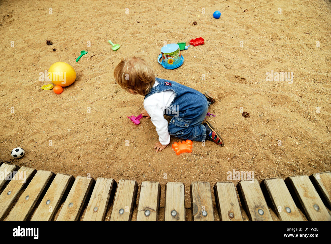 Baby in sand pit playing toys playground Stock Photo - Alamy