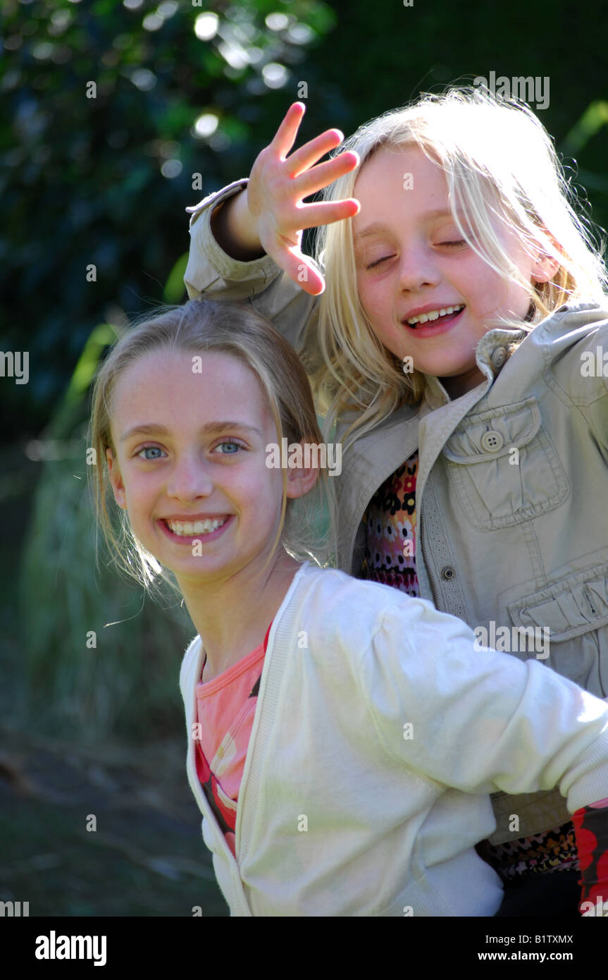 Photograph of two friends playing together and smiling having fun and ...