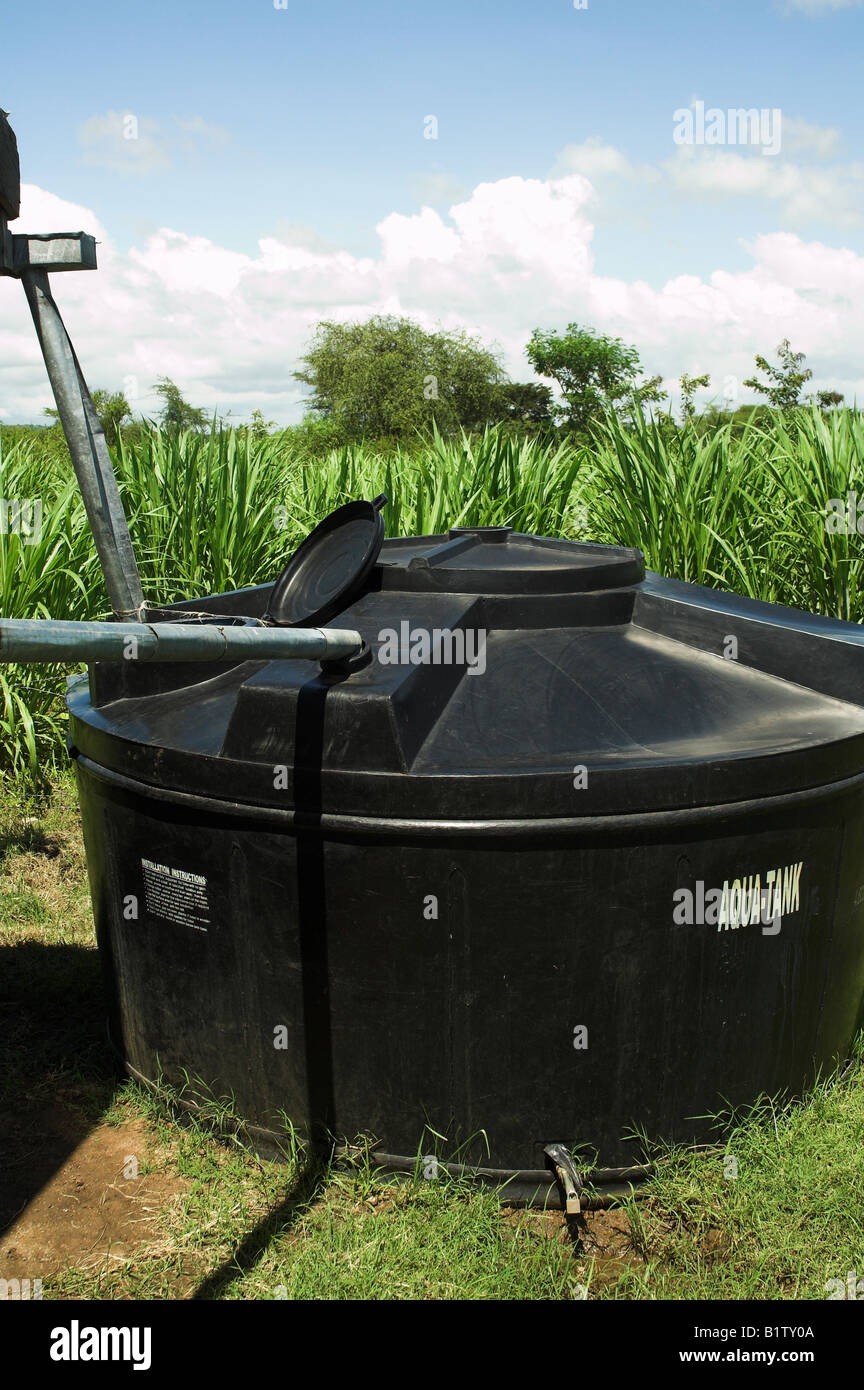 Water collection tank connected to guttering of building next to field ...