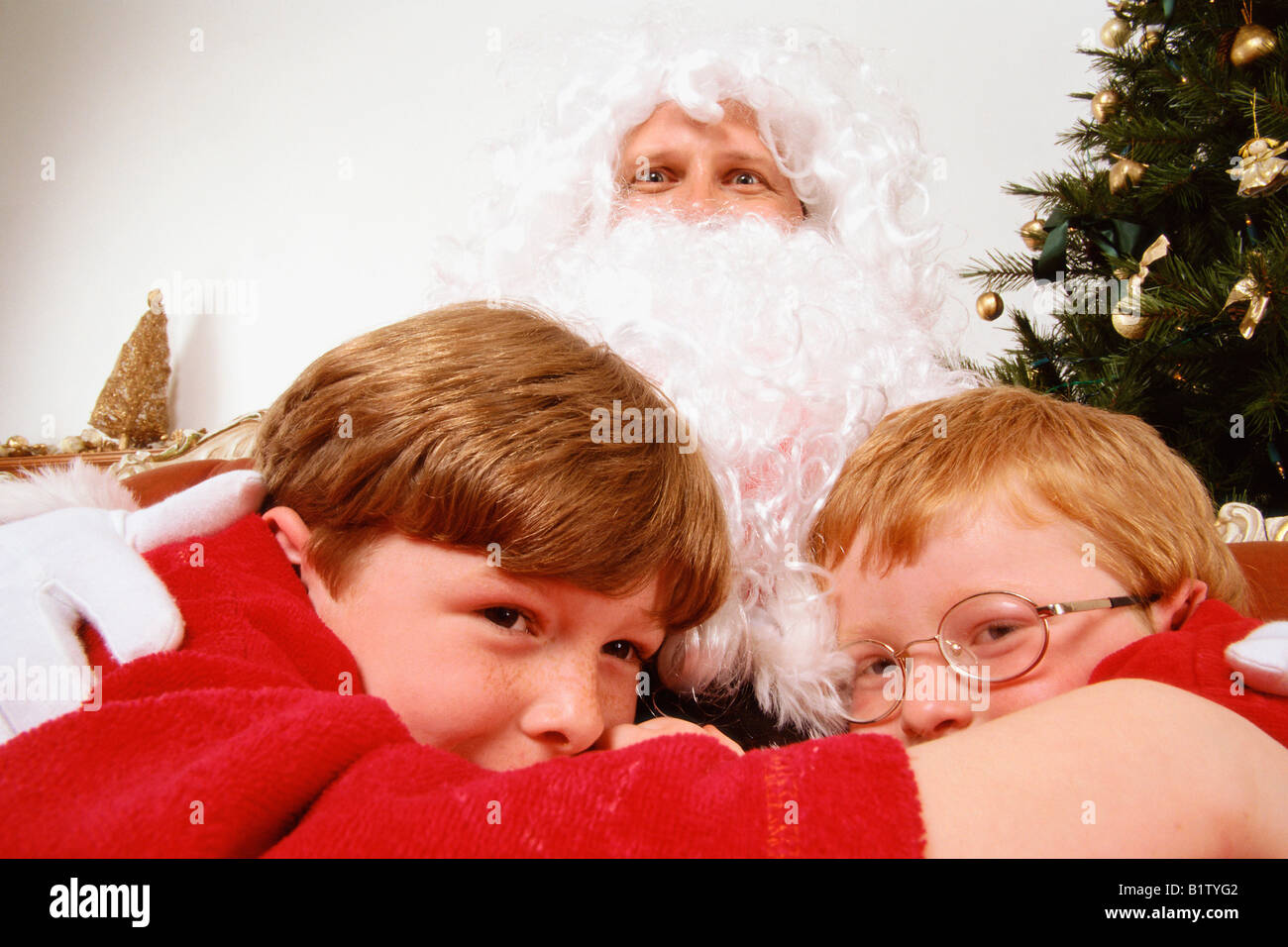 Two boys hugging Santa Stock Photo - Alamy