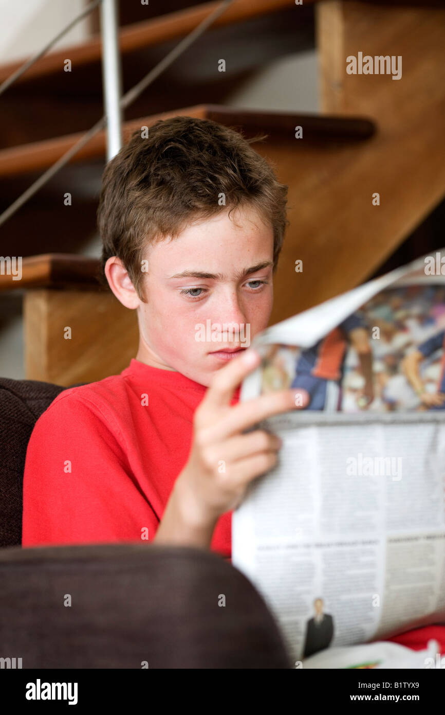 teenage boy reading newspaper Stock Photo - Alamy