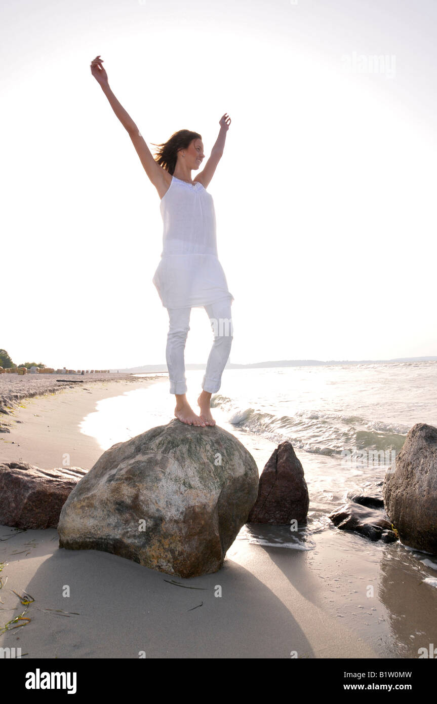 young woman 24 relaxing at beach, sunset, backlight, free, easy, happy ...