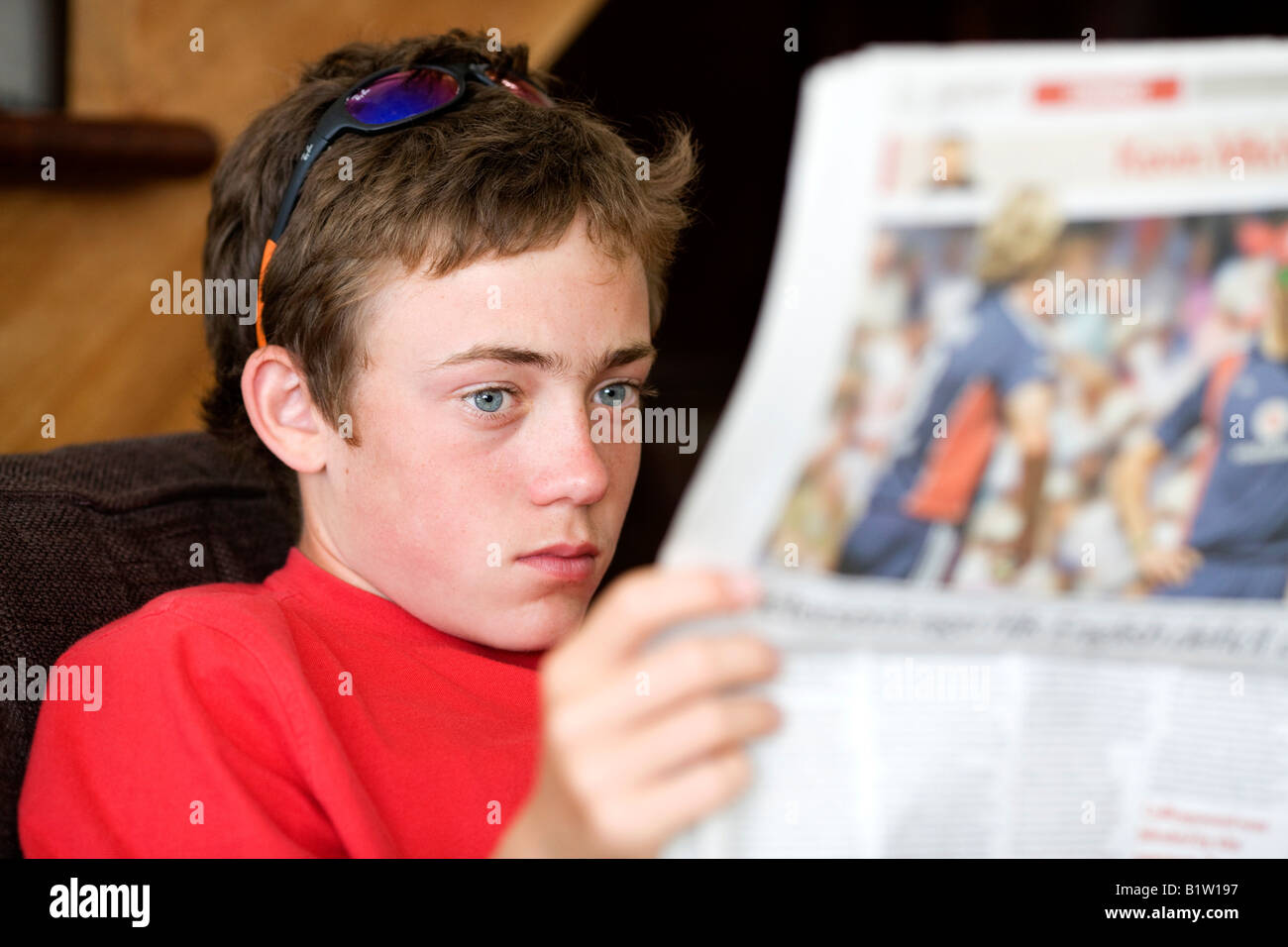 teenage boy reading newspaper Stock Photo - Alamy