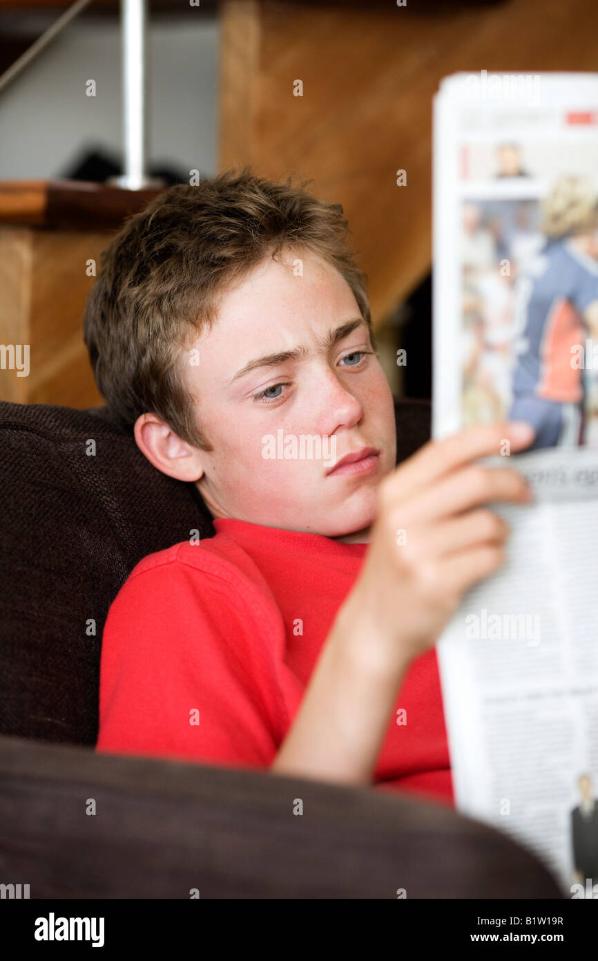 teenage boy reading newspaper Stock Photo - Alamy