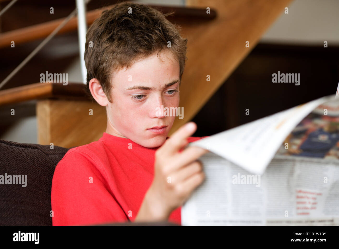 teenage boy reading newspaper Stock Photo - Alamy