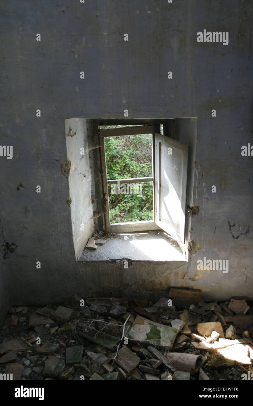 one small damaged window in derelict property Stock Photo - Alamy
