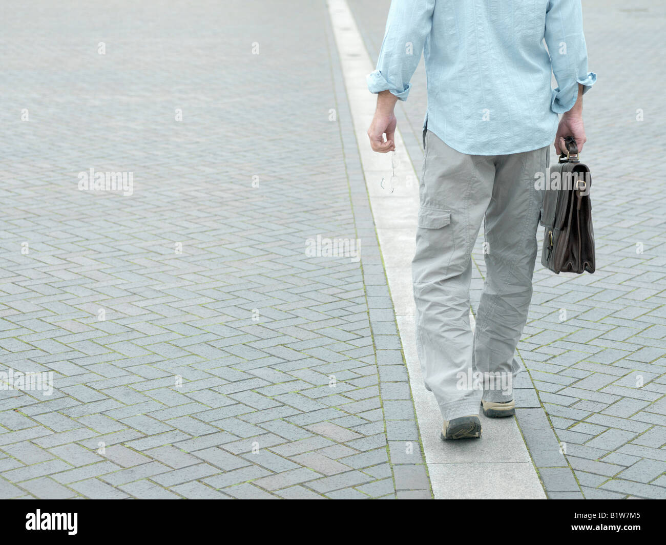 man walking along white line Stock Photo - Alamy