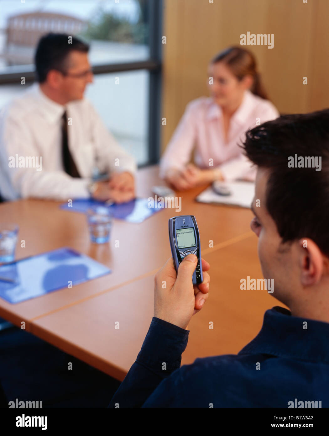 man texting on mobile phone at business meeting Stock Photo - Alamy