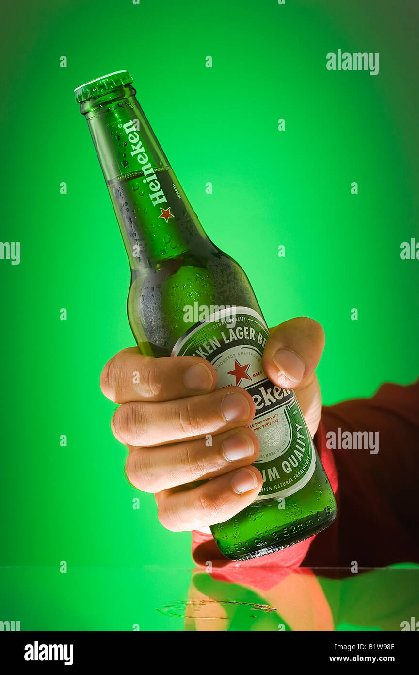 Hand grab a bottle of Heineken beer still life on green Serie of 3 ...