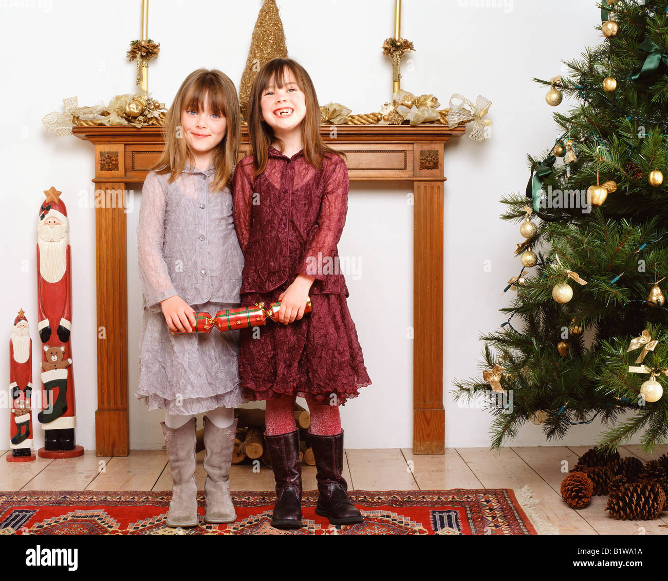 Two children holding a Christmas cracker Stock Photo - Alamy