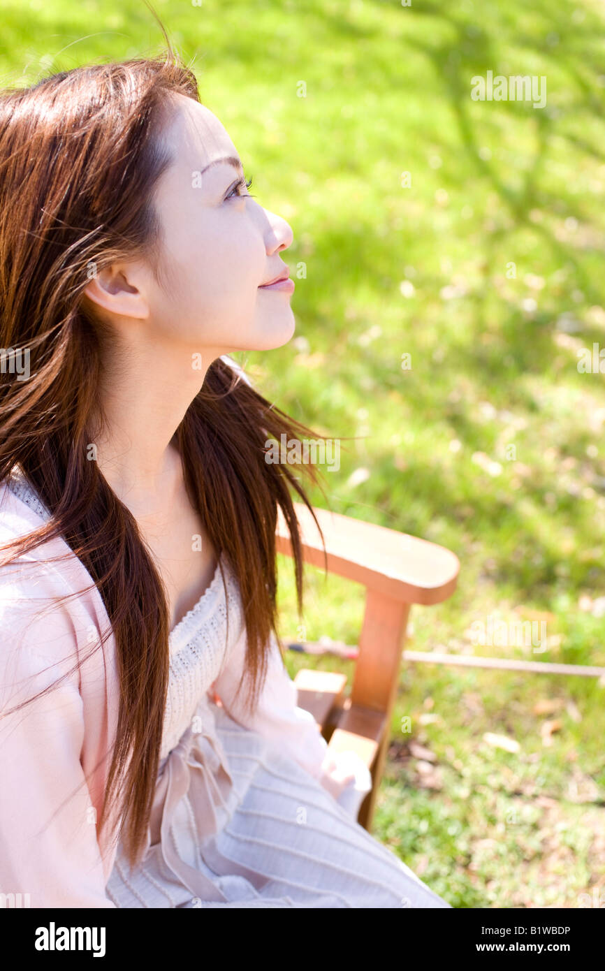Japanese young woman sitting on the bench Stock Photo - Alamy