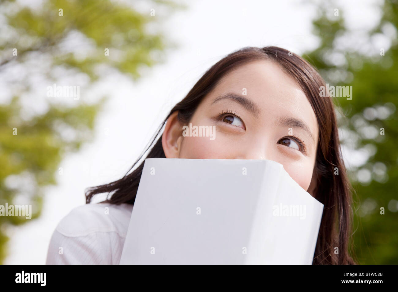 Japanese young woman reading a book in a park Stock Photo - Alamy