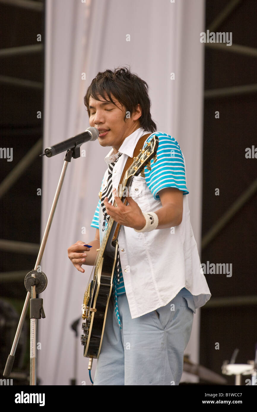 Young Asian male singer guitarist performing onstage at an outdoor ...