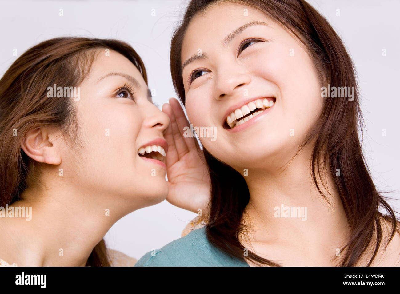 Japanese young woman talking secretively Stock Photo - Alamy
