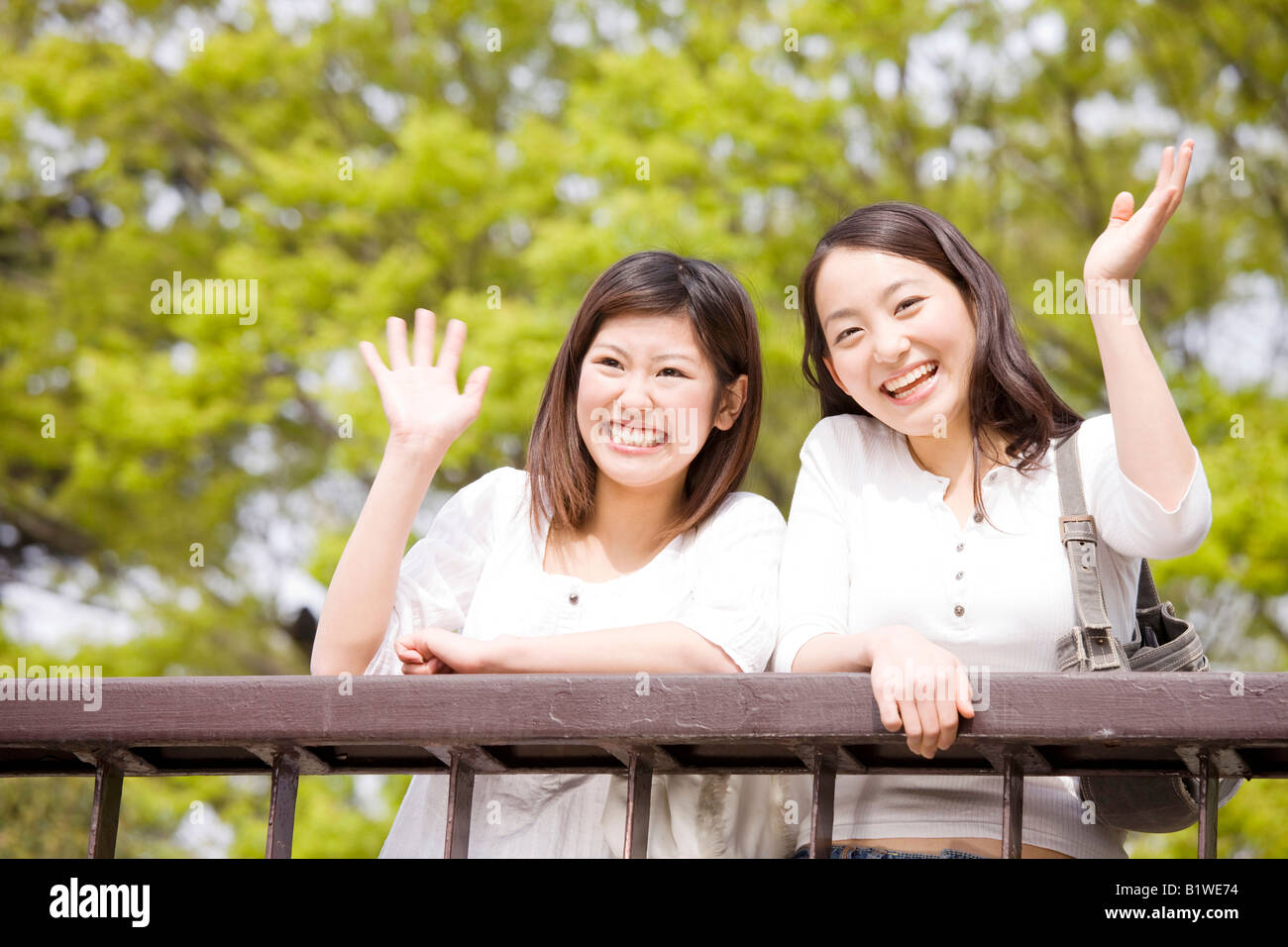 Japanese young women waving their hands Stock Photo - Alamy