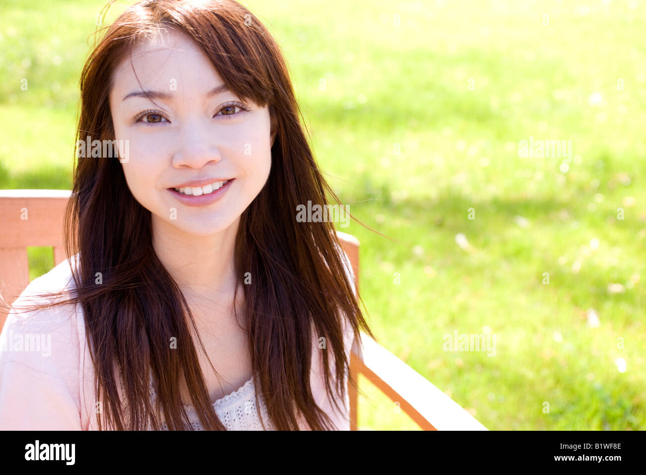 Japanese young woman sitting on the bench Stock Photo - Alamy
