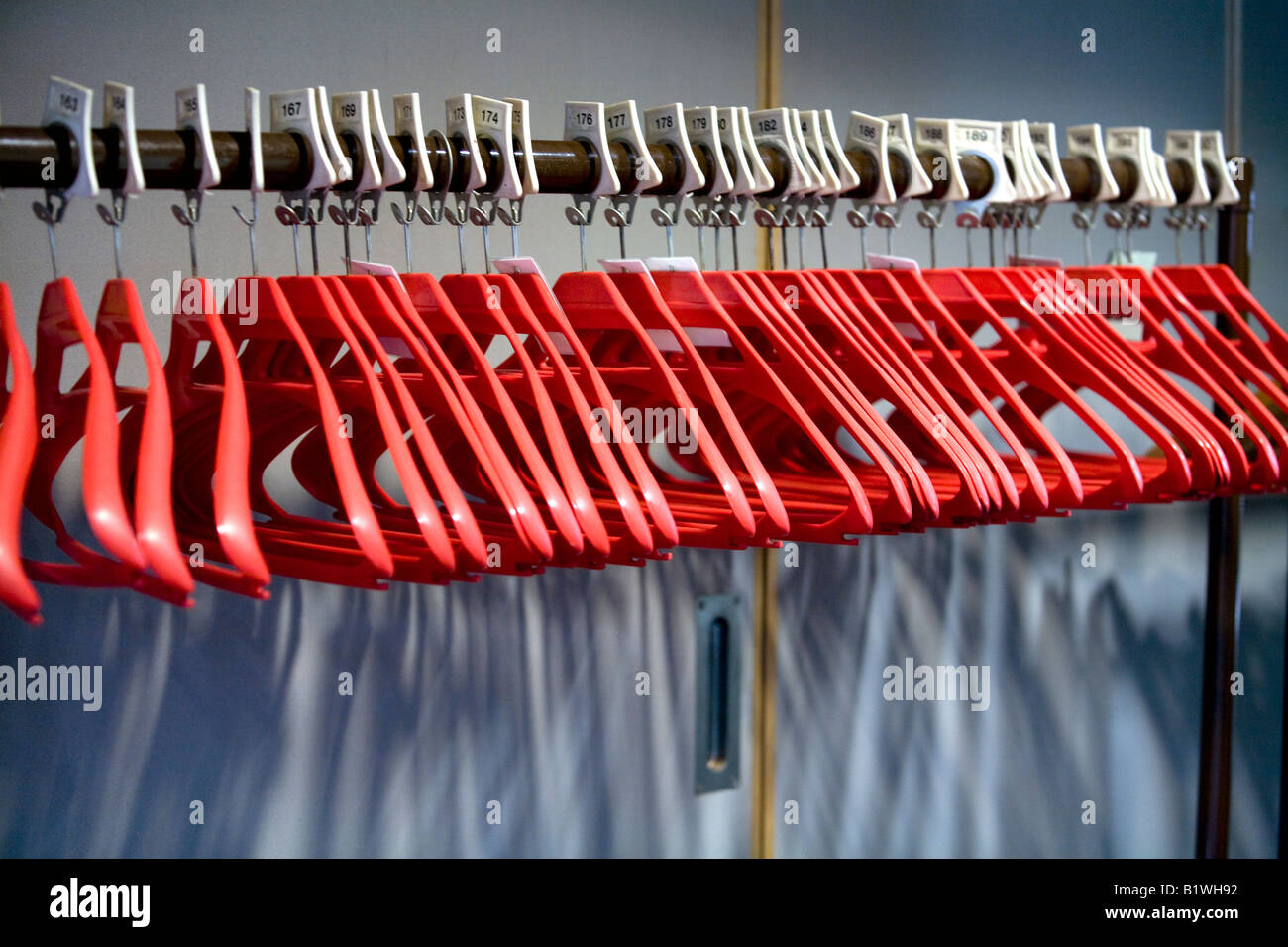 A row of empty red coat hangers Stock Photo - Alamy