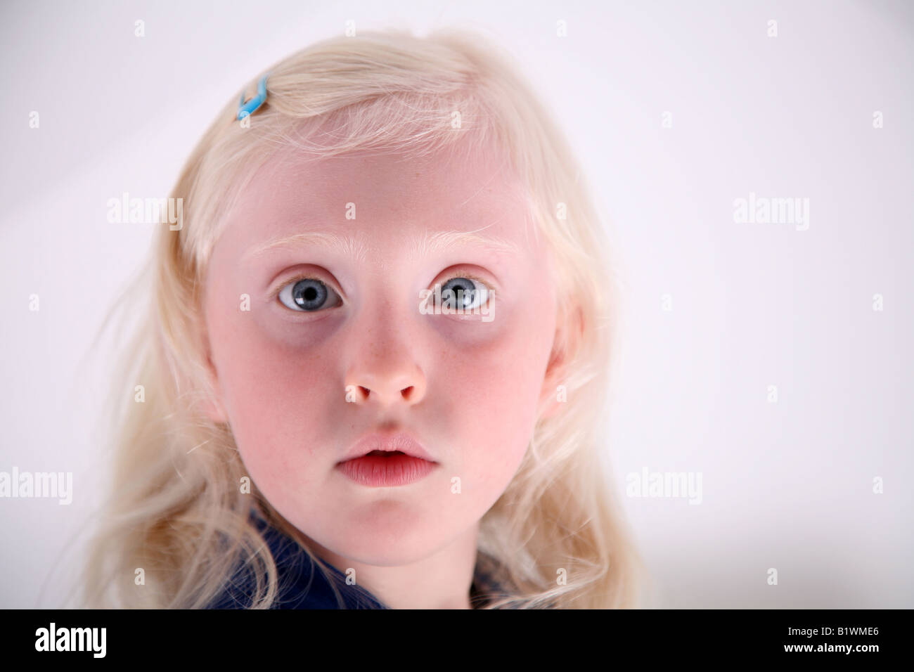 Full frontal face shot of a little blonde haired school girl against a ...