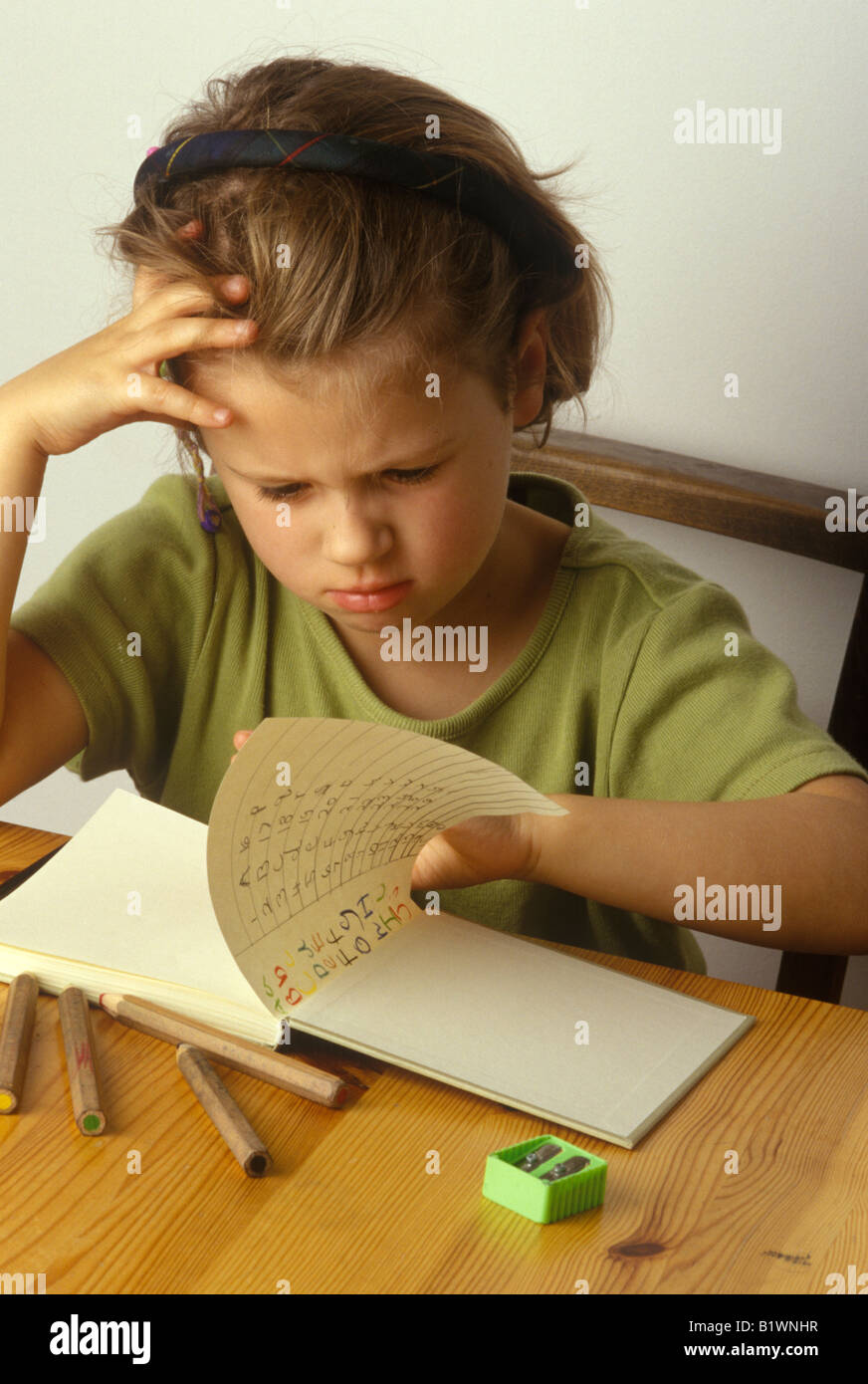 little girl doing her homework and looking stressed Stock Photo - Alamy