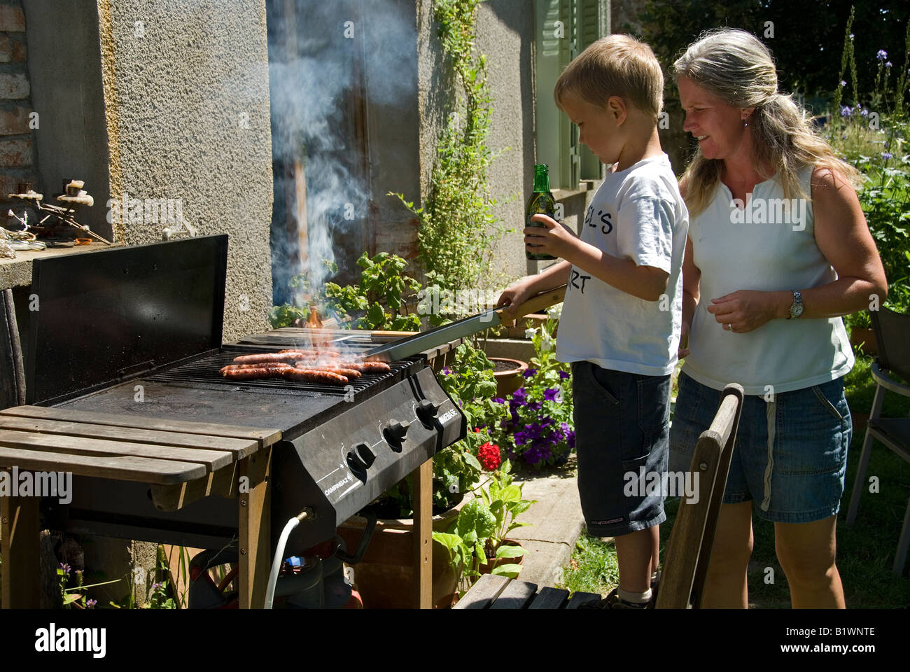 Stock photo of a young boy learning how to barbecue Stock Photo - Alamy