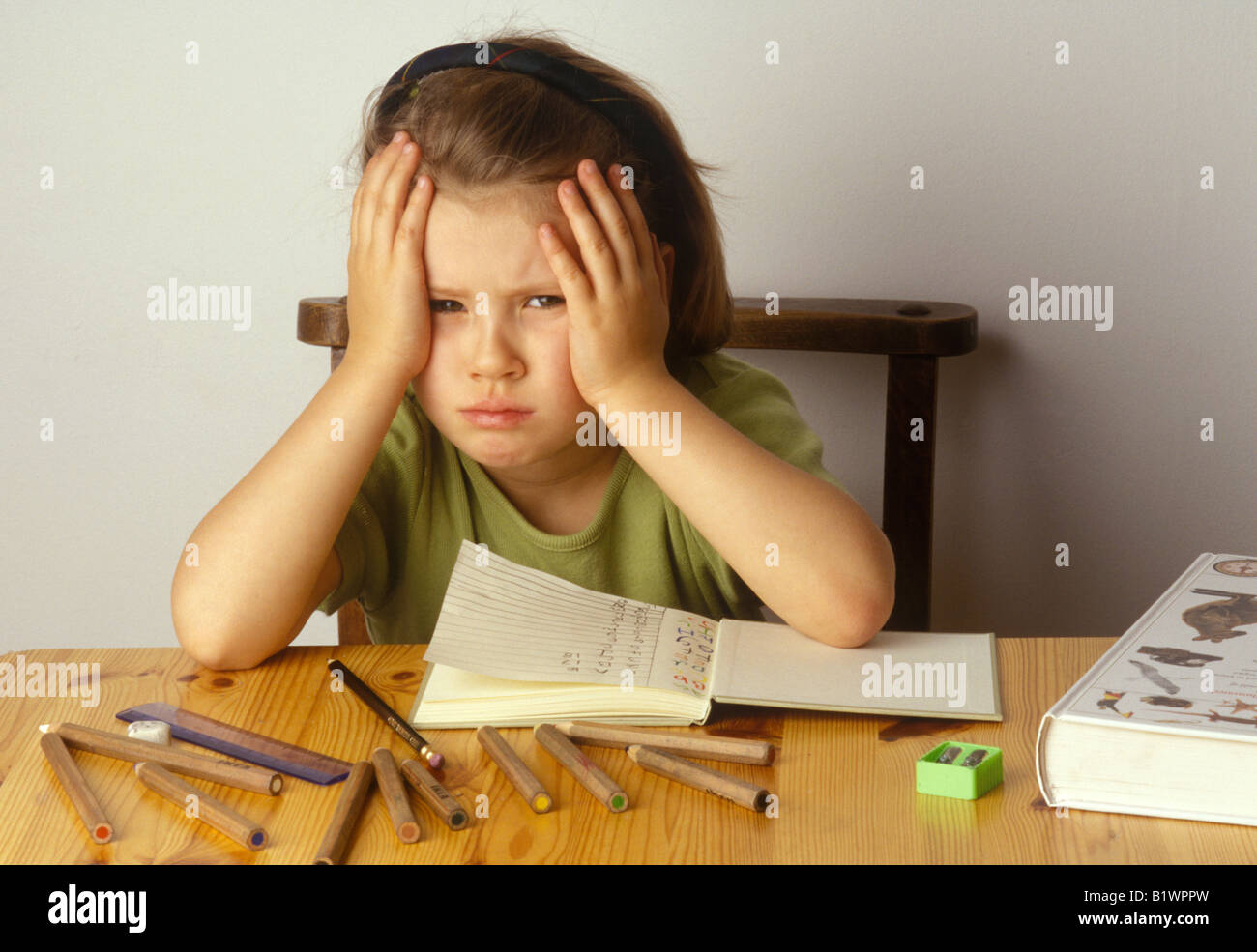 little girl doing her homework and looking stressed Stock Photo - Alamy