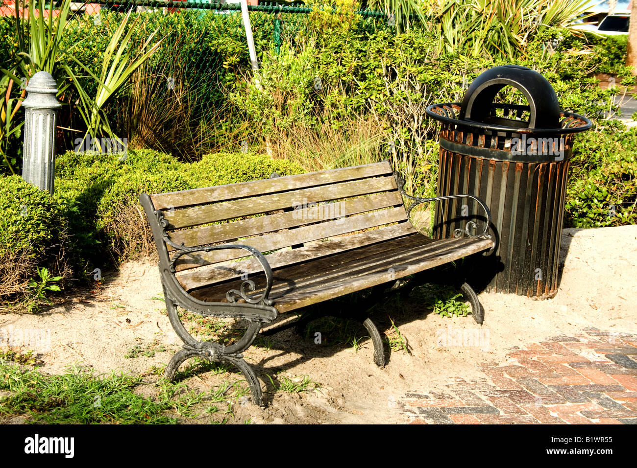 Weathered wood and metal bench next to trash bin in Atlantic Beach ...