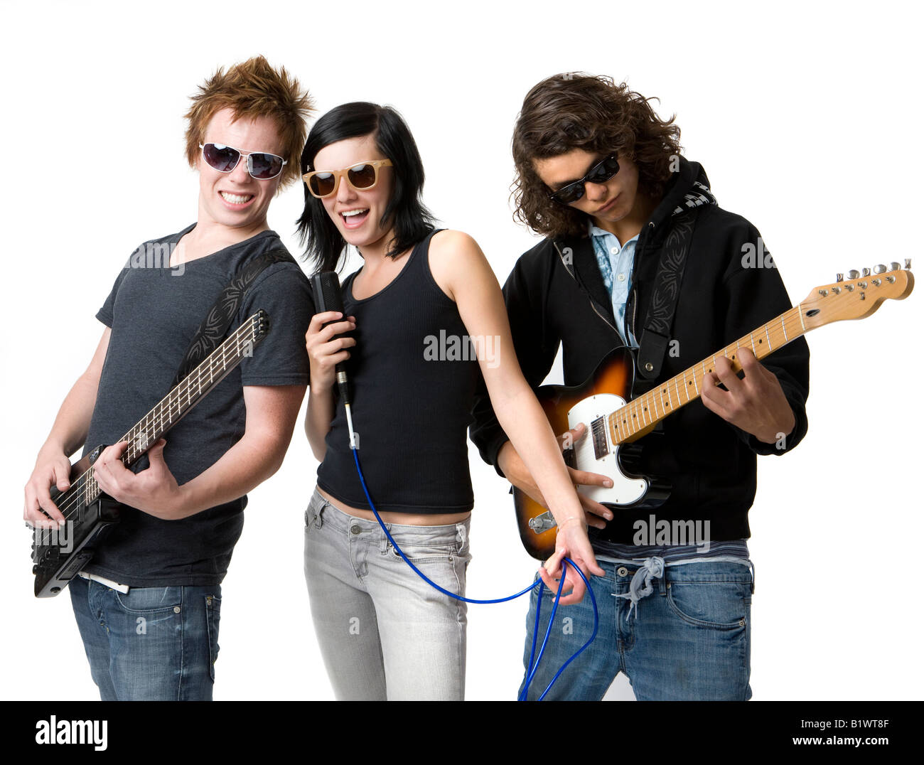 Three bandmates sing and play guitar Stock Photo - Alamy