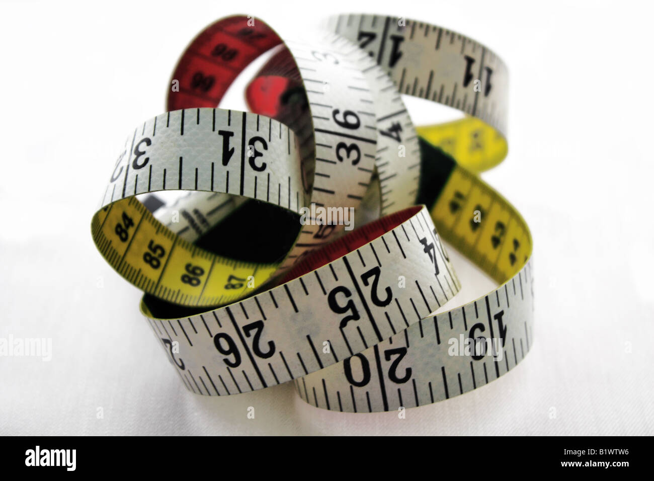 A rolled up tape measure on a white background Stock Photo - Alamy