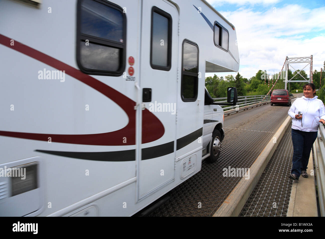 Camper passing tourist crossing the Hagwilget bridge over Bulkley river ...