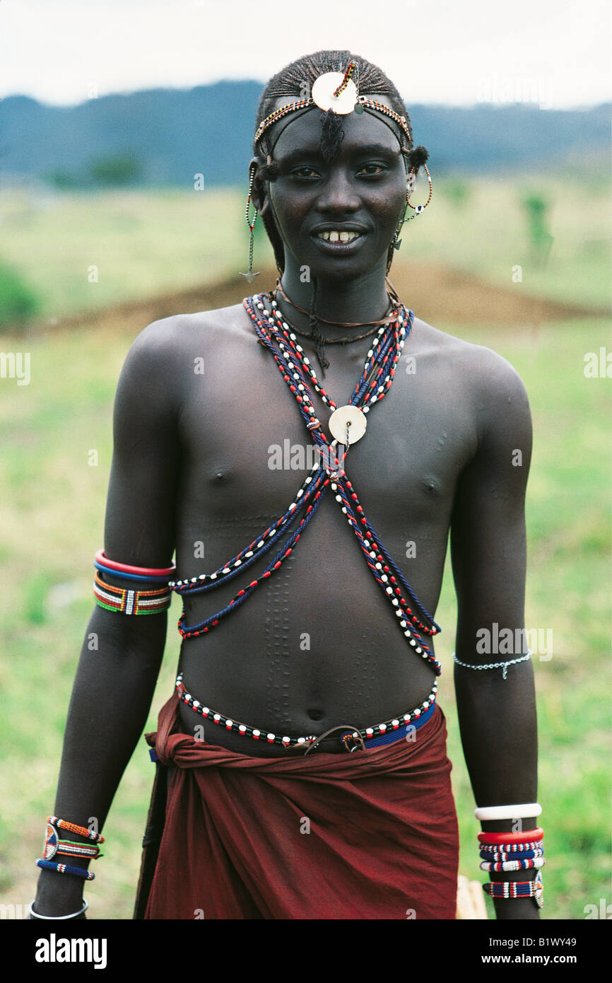 Maasai moran or warrior in traditional dress wearing crossed over bead necklaces strings only ...