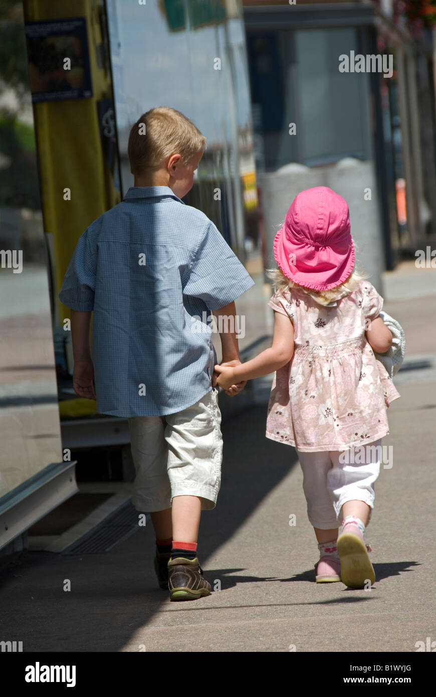 Stock photo of a young child walking hand in hand with his younger ...