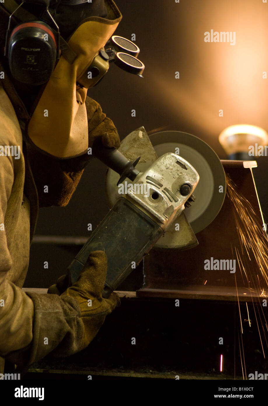 Welder cleaning metal with a grinder Stock Photo - Alamy
