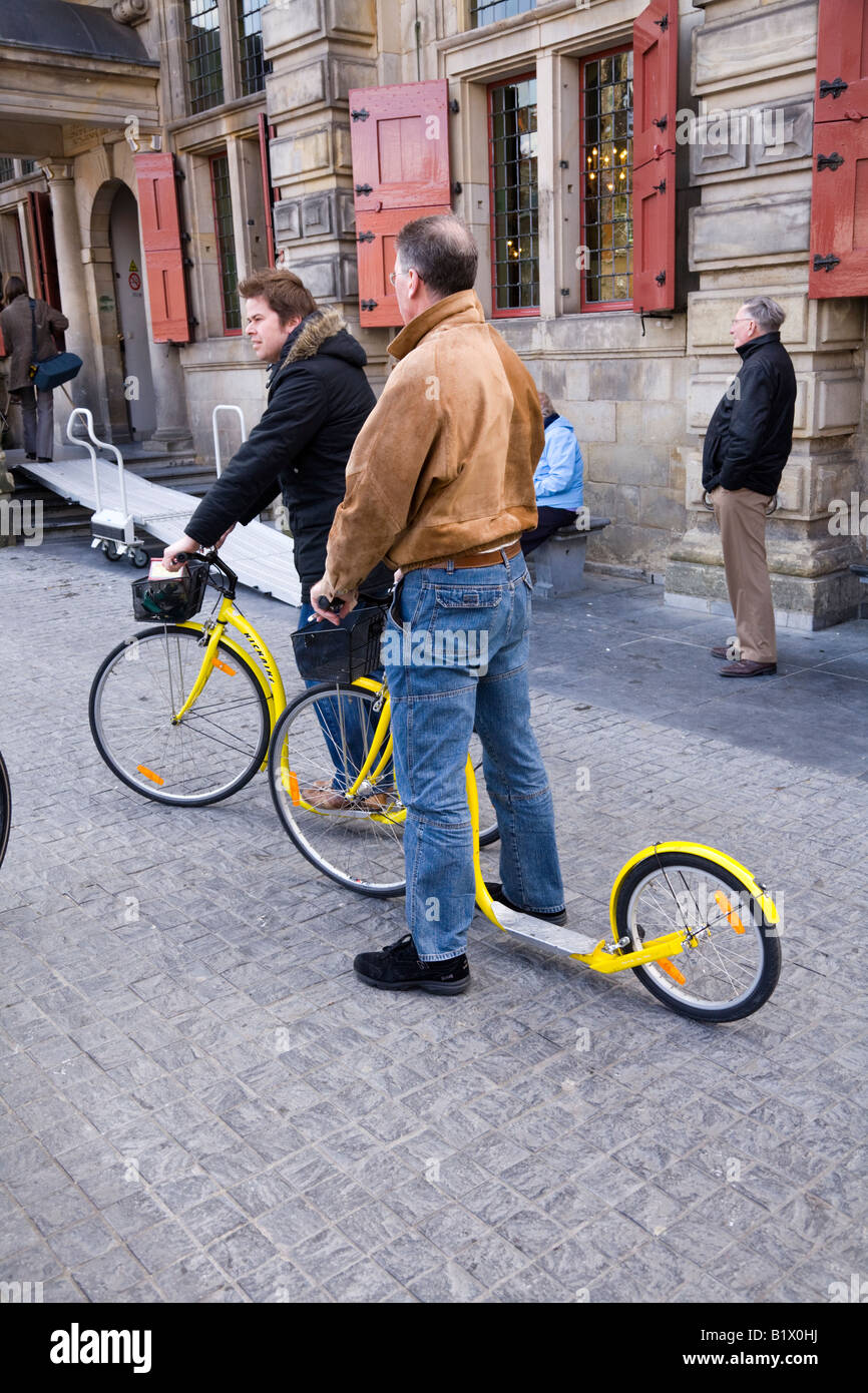 Two men on Kickbikes at the side of the Stadhuis, Markt Square, in ...
