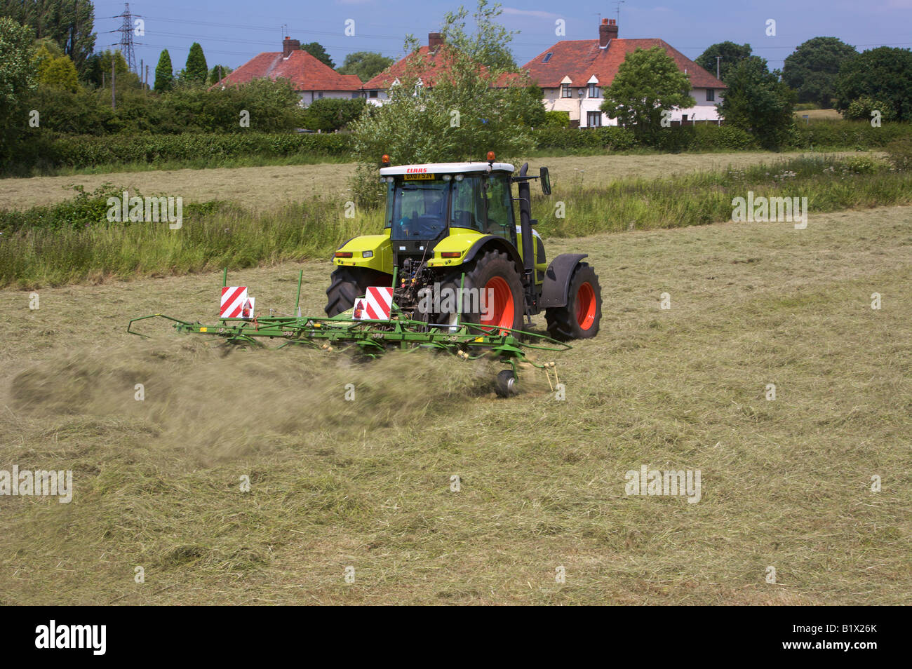 Turning Hay with a Claas Ares 697 ATZ Tractor UK Stock Photo - Alamy