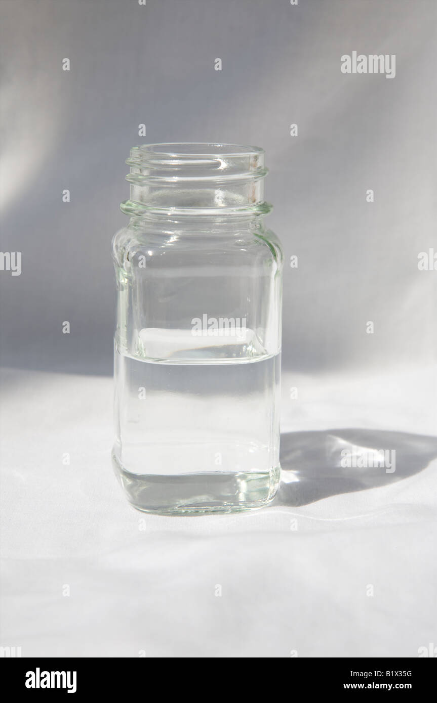 OPEN GLASS BOTTLE CONTAINING CLEAR LIQUID ON A WHITE BACKGROUND Stock ...