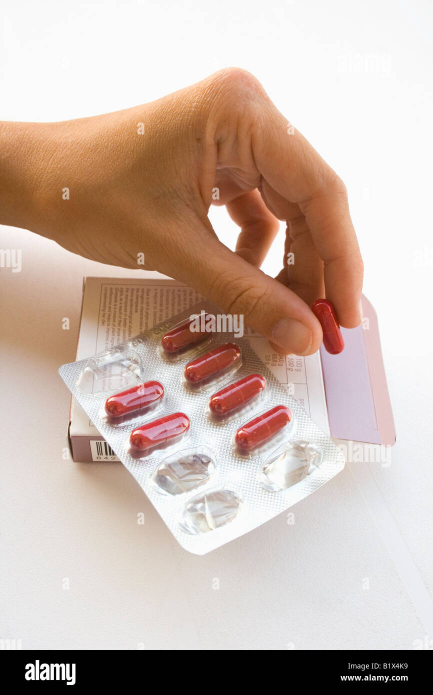 Hand holding red tablet Stock Photo - Alamy