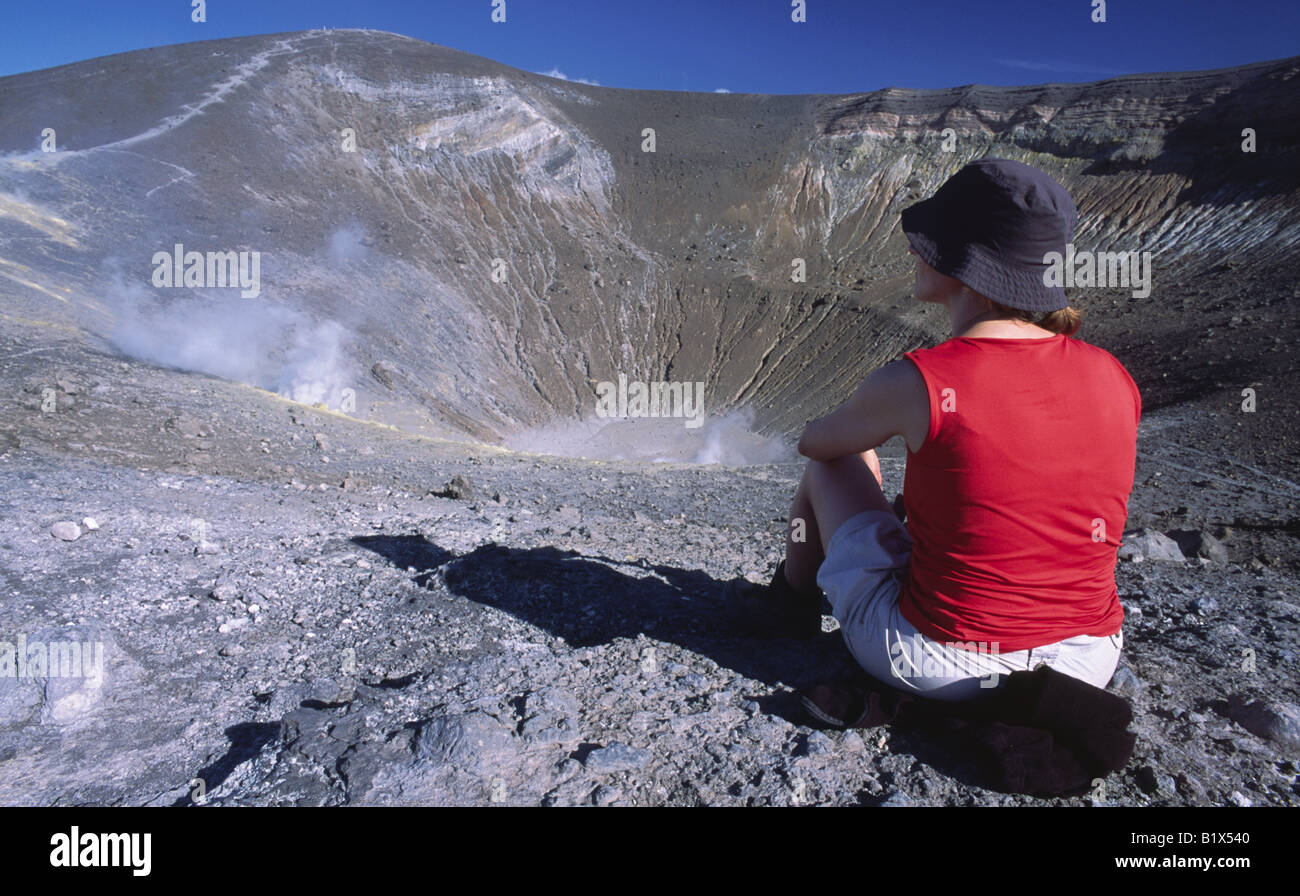 Young woman looking into the main crater on the volcanic island of ...