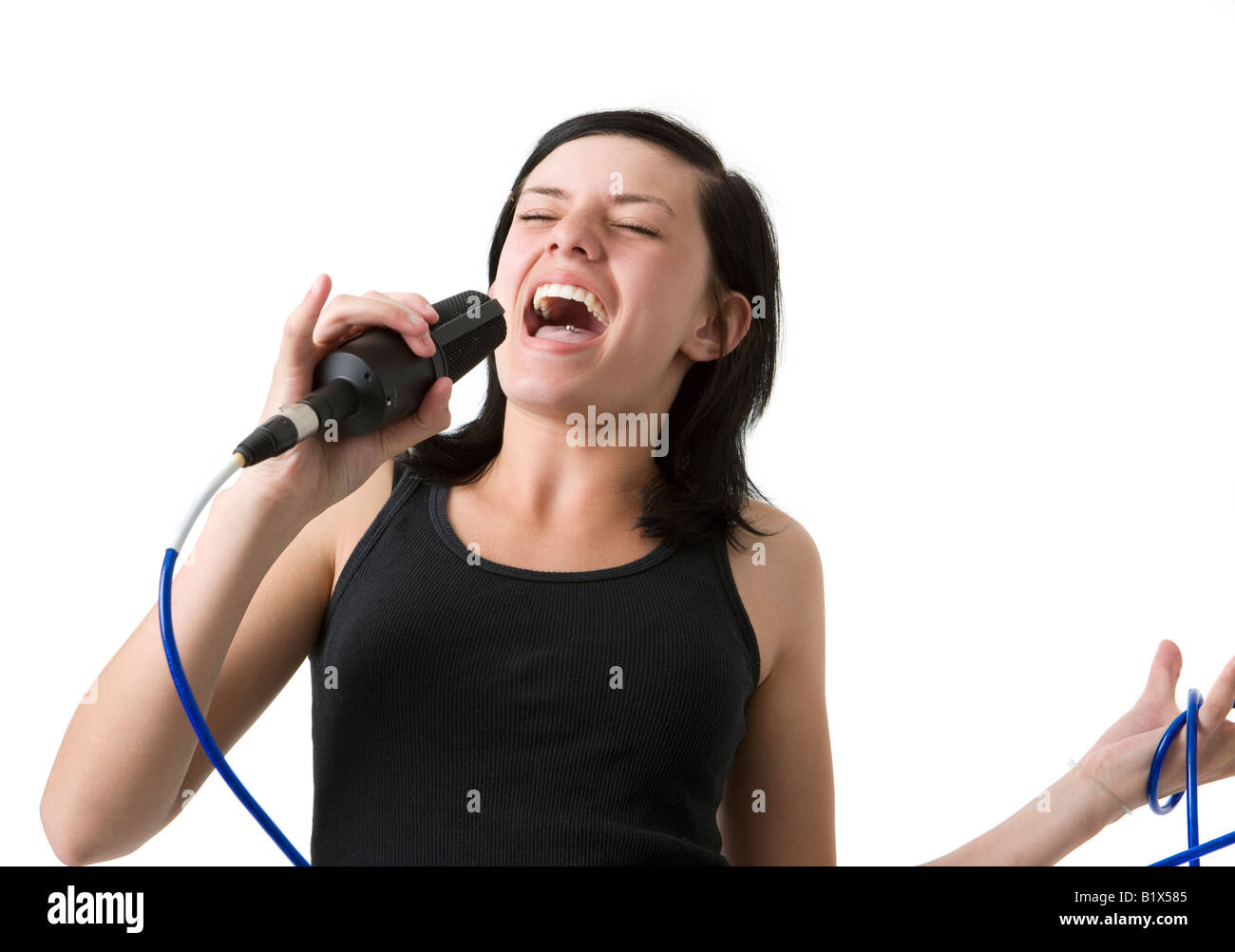 A girl sings loudly into a mic Stock Photo - Alamy