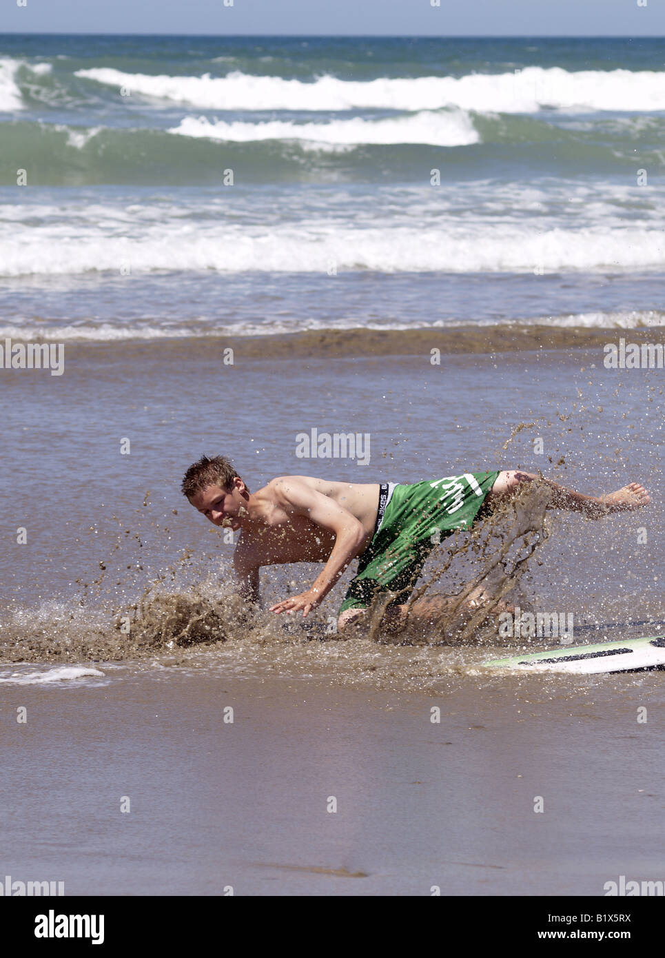 Teenager falling of skimboard Stock Photo - Alamy