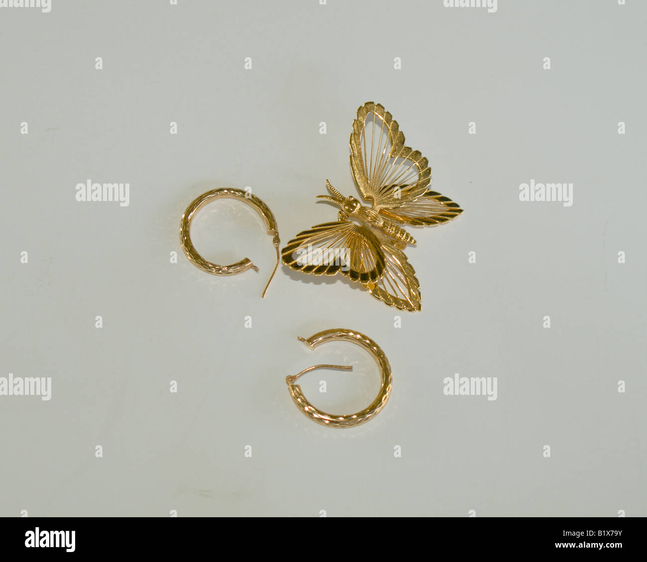 A GOLD BUTTERFLY PIN AND EARRINGS ARE SET ASIDE AFTER USE Stock Photo ...