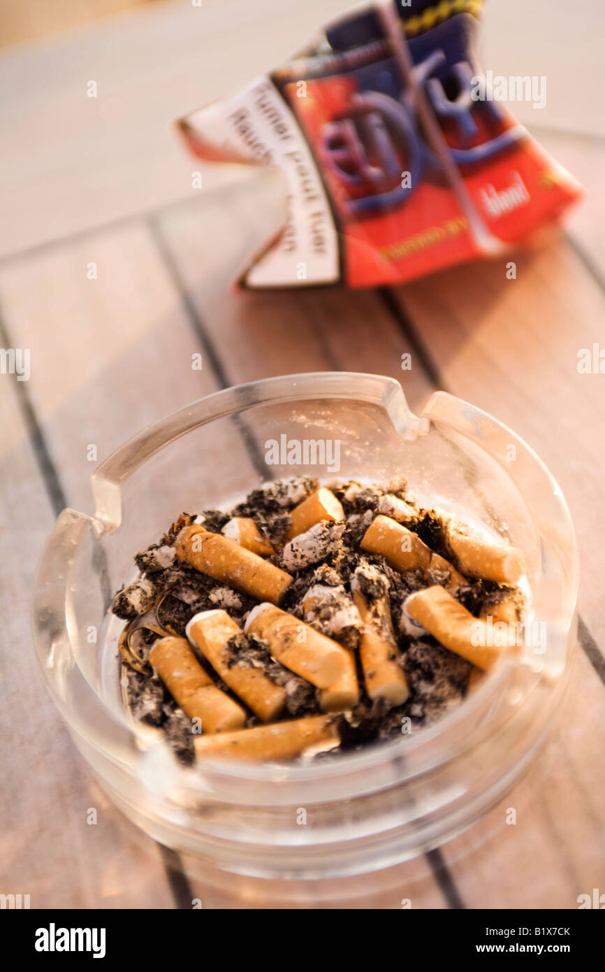 Empty pack of cigarette with full ashtray Stock Photo - Alamy